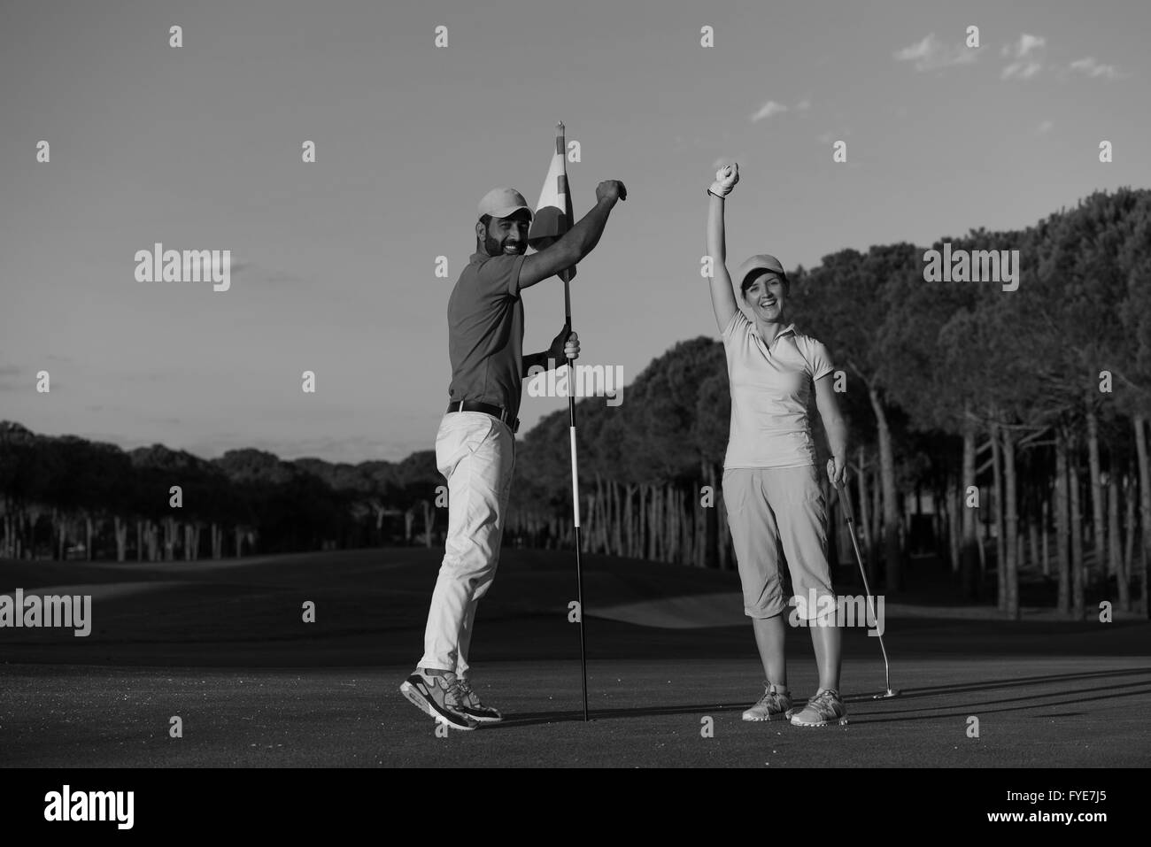 male golf instructor teaching female golf player, personal trainer ...