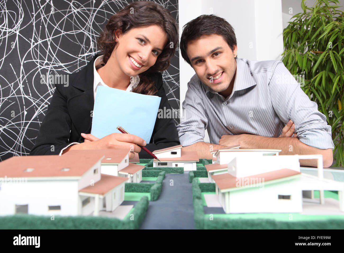 Agent and client looking at a new-build property model Stock Photo - Alamy