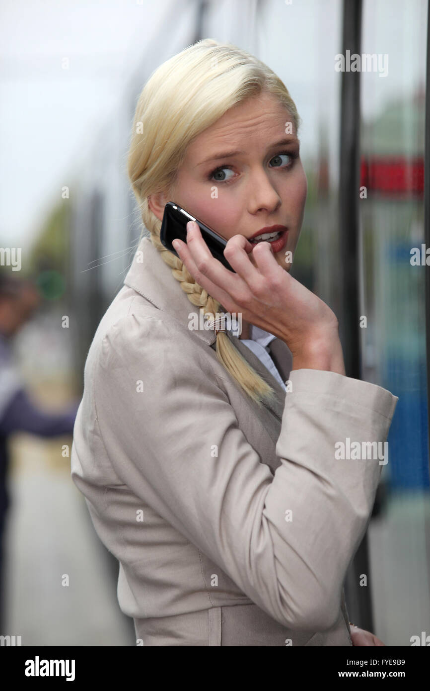 blonde woman at phone having an anxious face expression Stock Photo - Alamy
