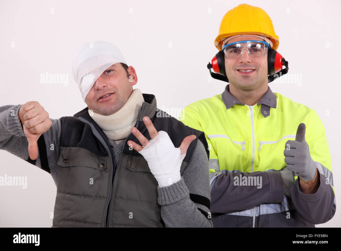 Healthy construction worker standing next to an injured man Stock Photo ...