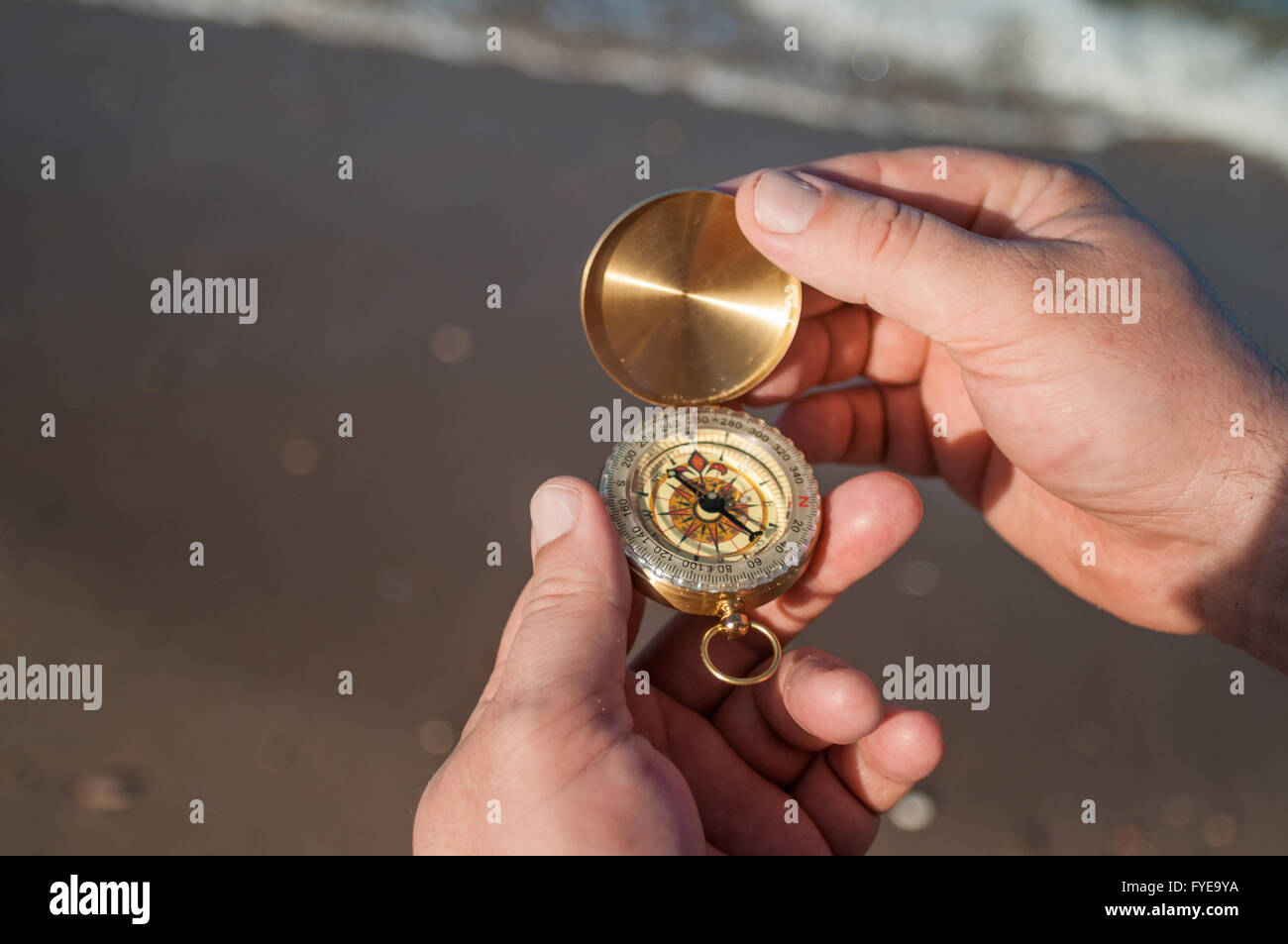 the compass in hands of the men on the beach Stock Photo - Alamy