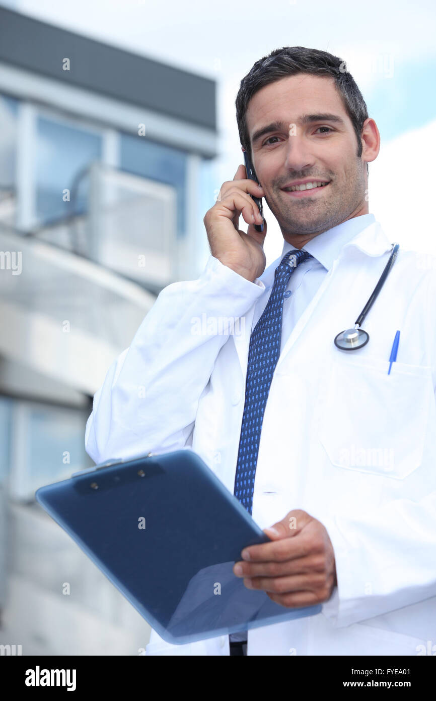 Doctor using his mobile phone outside a hospital building Stock Photo ...