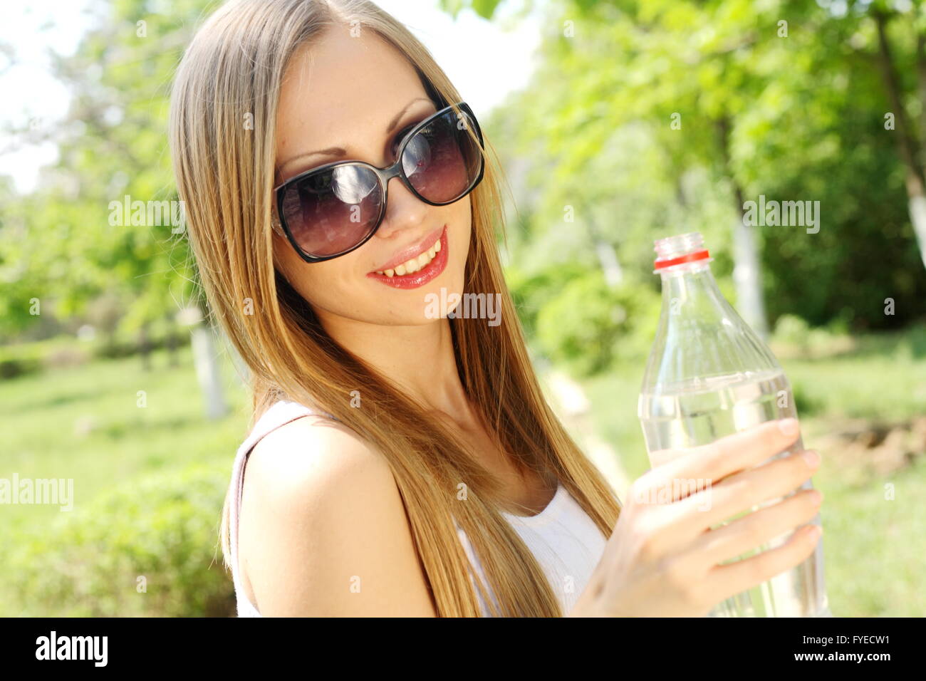 beautiful woman drinking water at summer green park Stock Photo - Alamy
