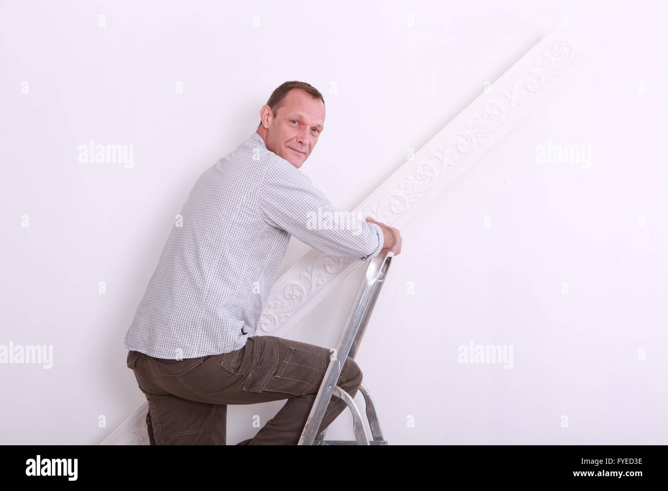 Man with step-ladder holding roll of wallpaper Stock Photo - Alamy