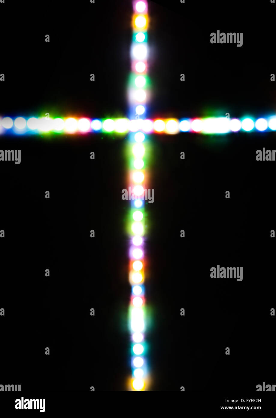 Cross made with several light colors with black background Stock Photo ...