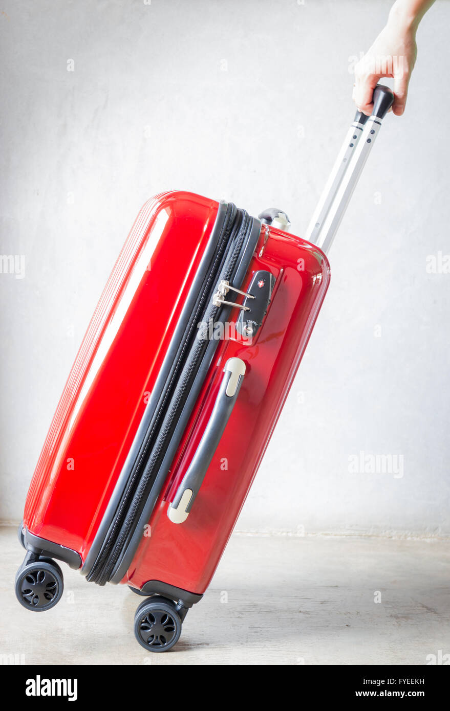 Hand on red traveling suitcase, stock photo Stock Photo - Alamy