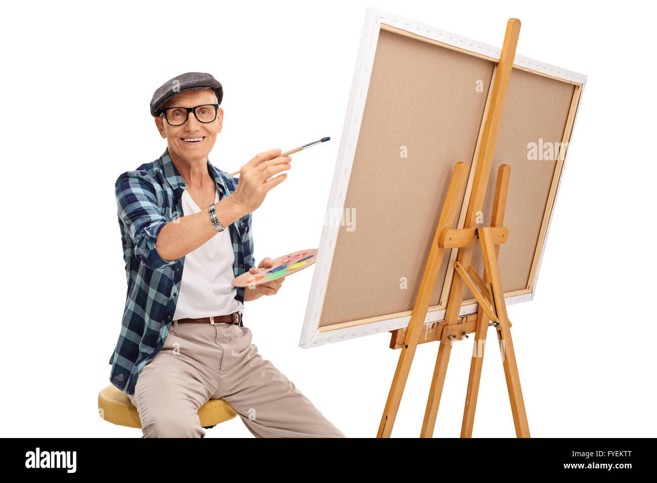 Studio shot of a senior artist painting on a canvas and looking at the ...