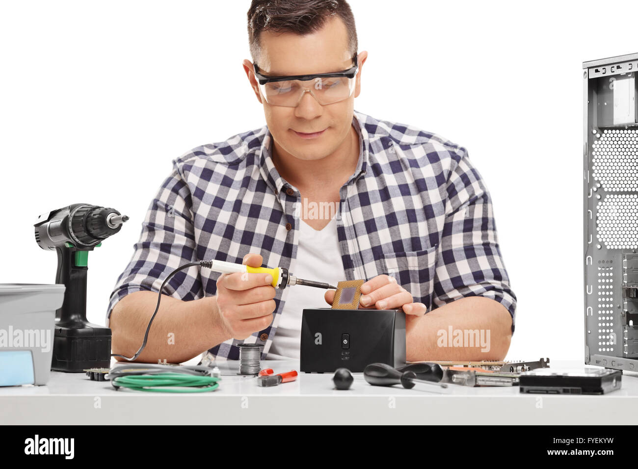 Young PC technician working with soldering iron and repairing a ...
