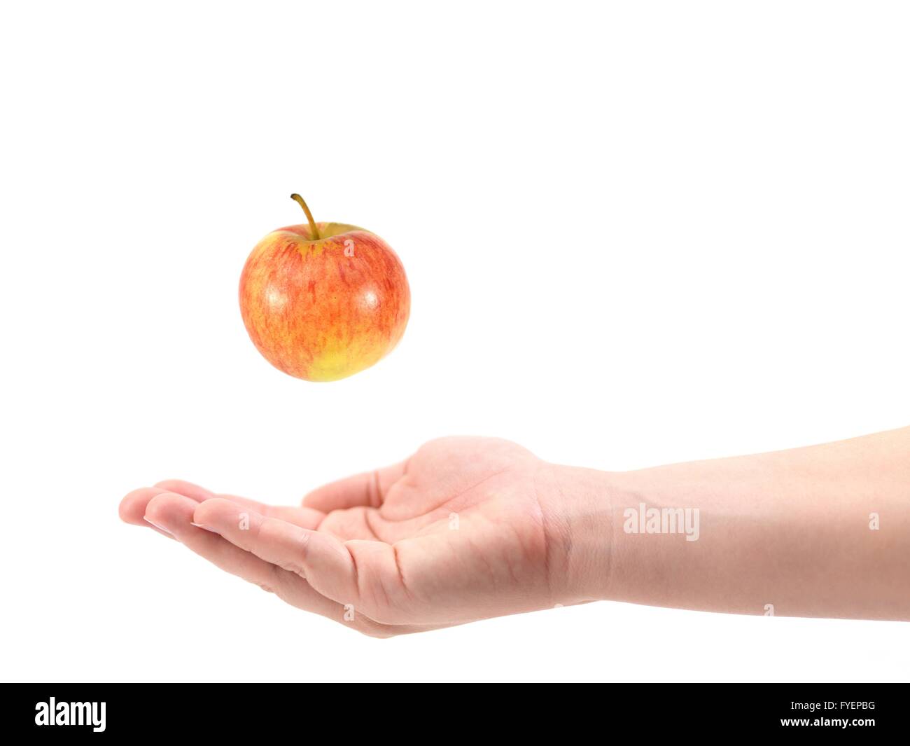 A female hand catching an apple isolated against a white background ...