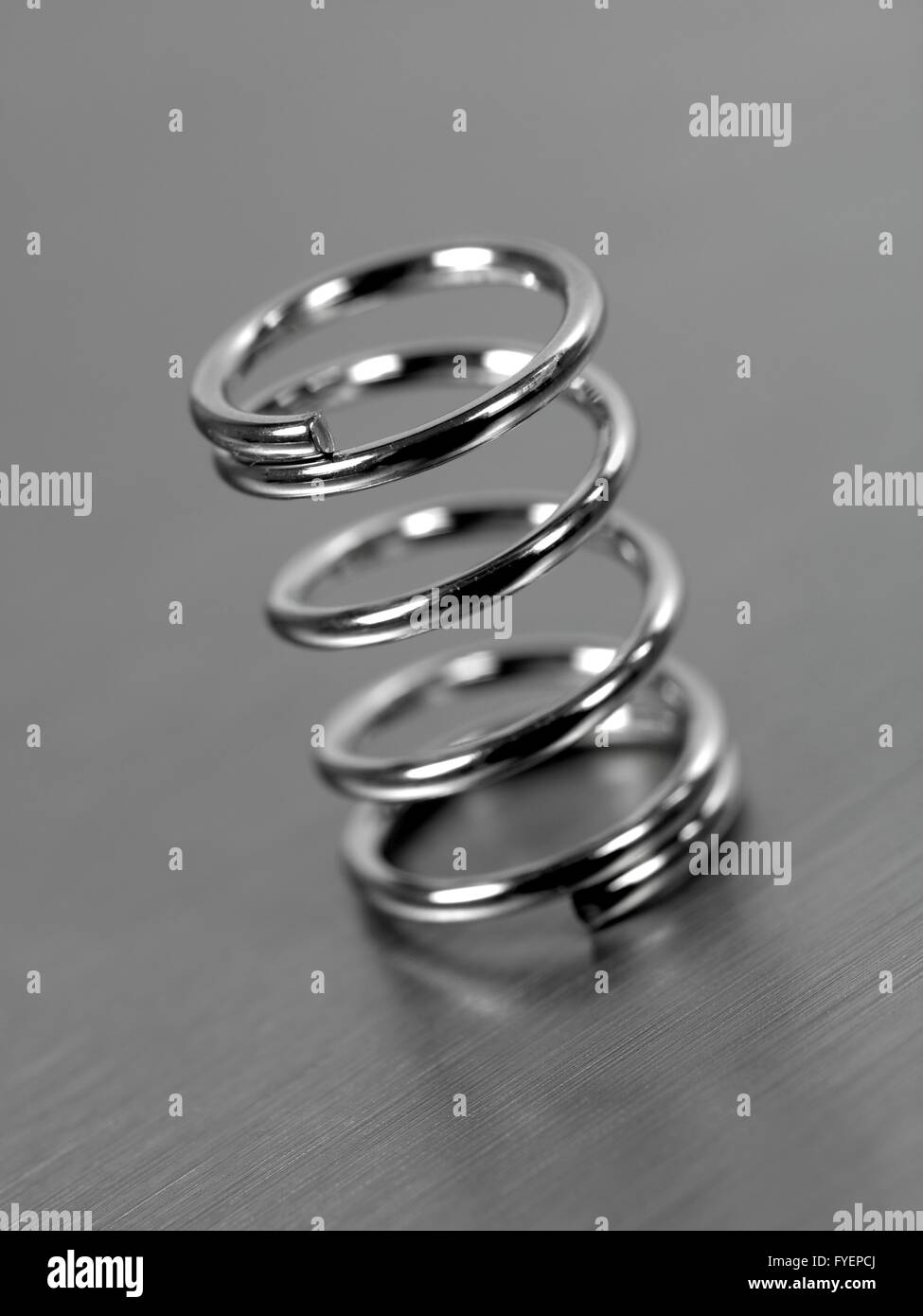 A spring isolated against a silver background Stock Photo - Alamy