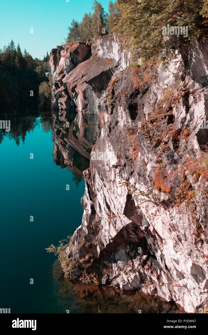 Rocks and trees reflected in water Stock Photo - Alamy