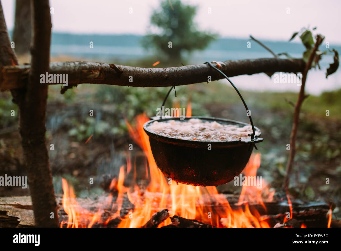 Fish soup to cook on fire in nature Stock Photo - Alamy