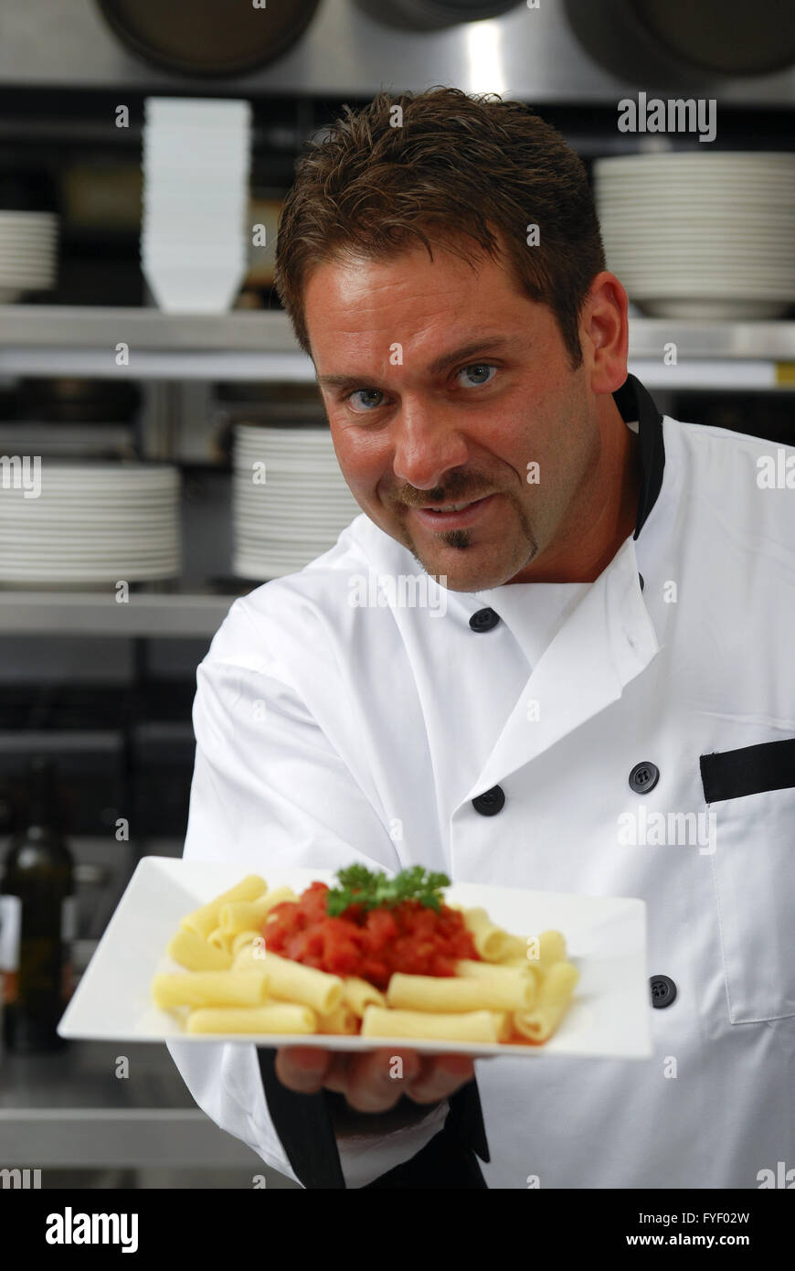 Smiling chef with plate of pasta Stock Photo - Alamy
