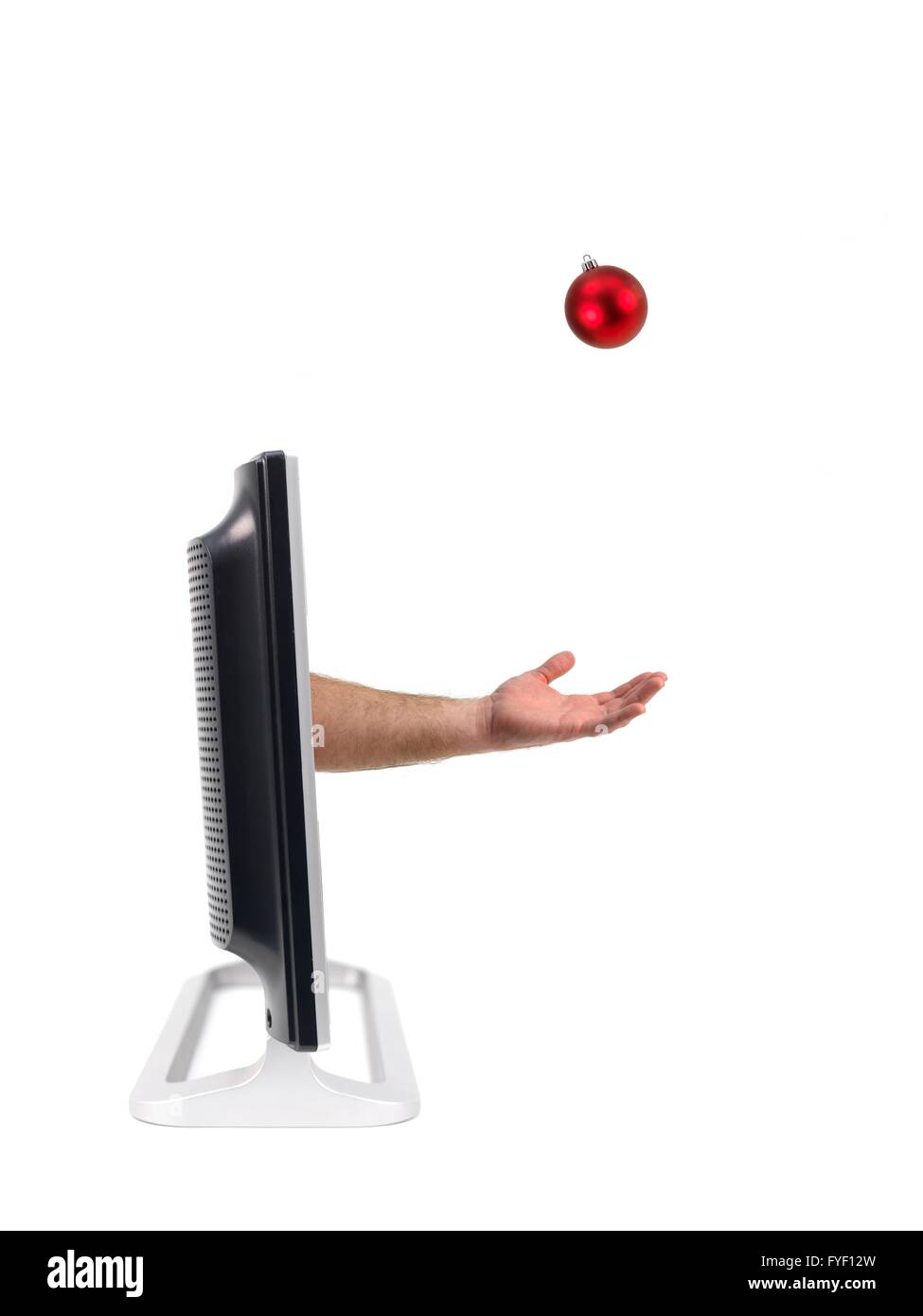 A flat screen tv with a hand reaching for a christmas ornamnt Stock ...
