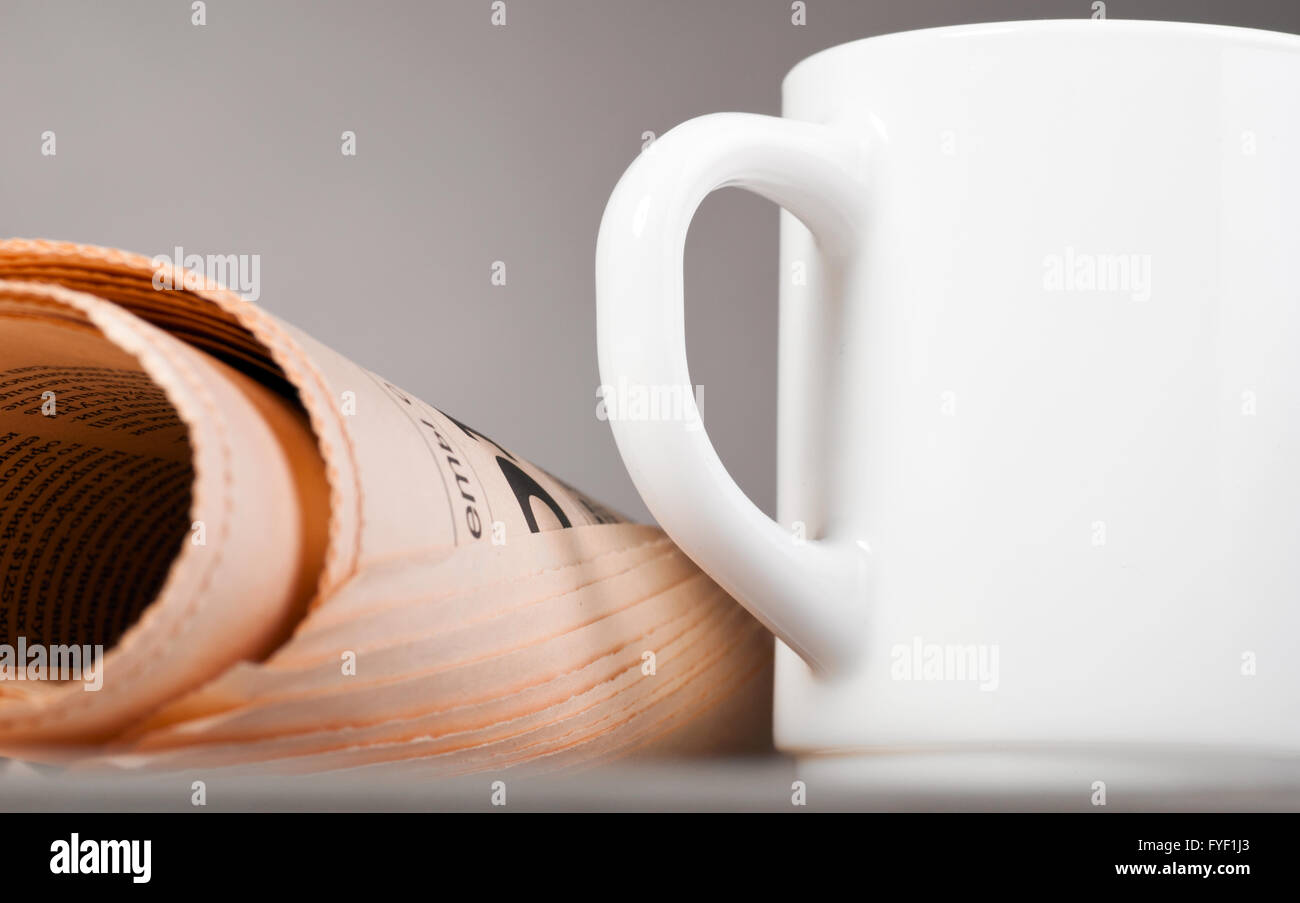 cup and folded newspaper Stock Photo - Alamy
