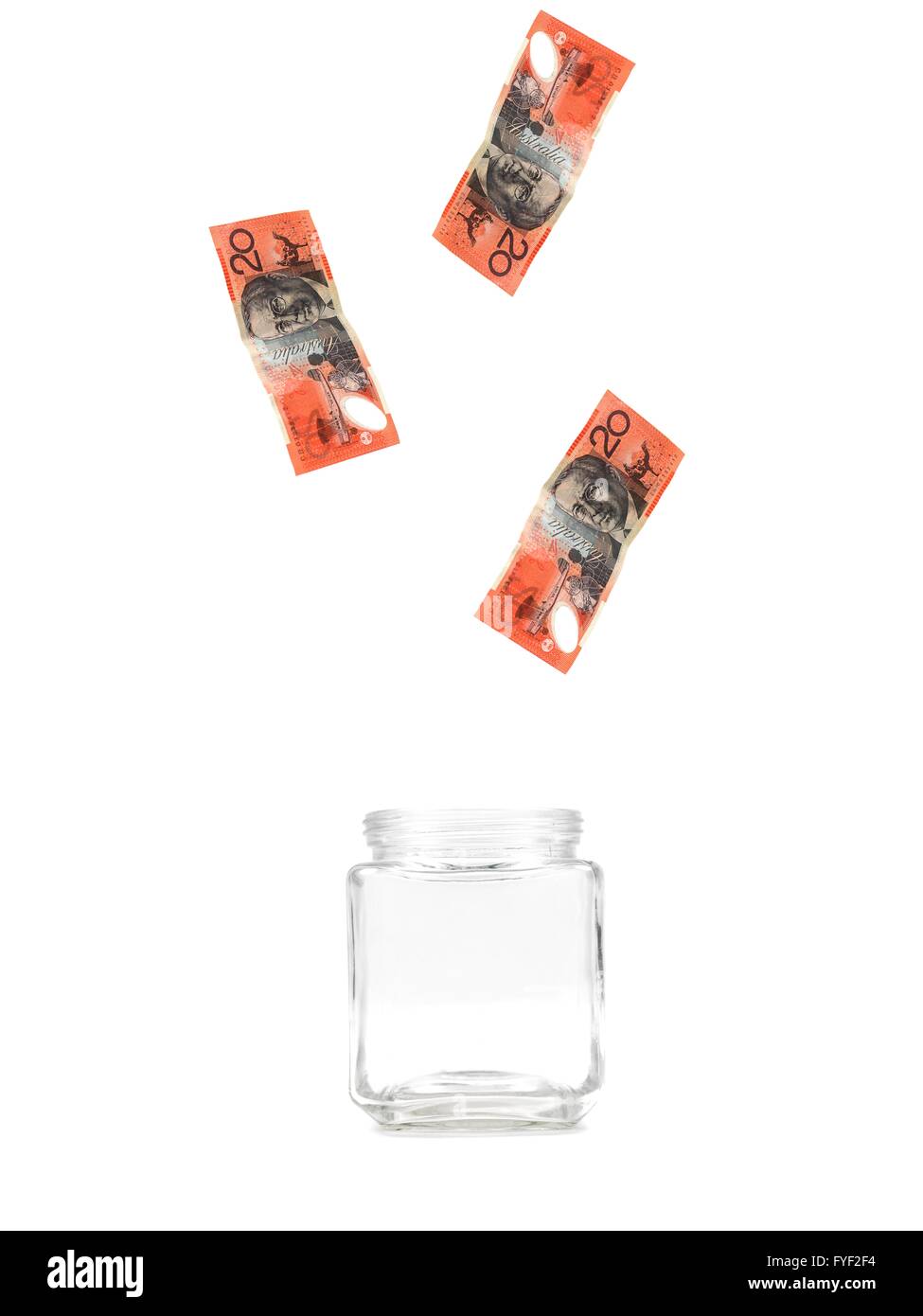Australian twenty dollar notes floating into a jar isolated against a ...