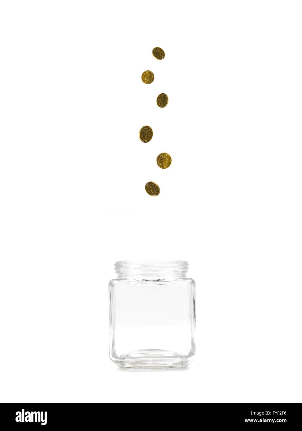 Coin dropping into an empty jar isolated against a white background ...