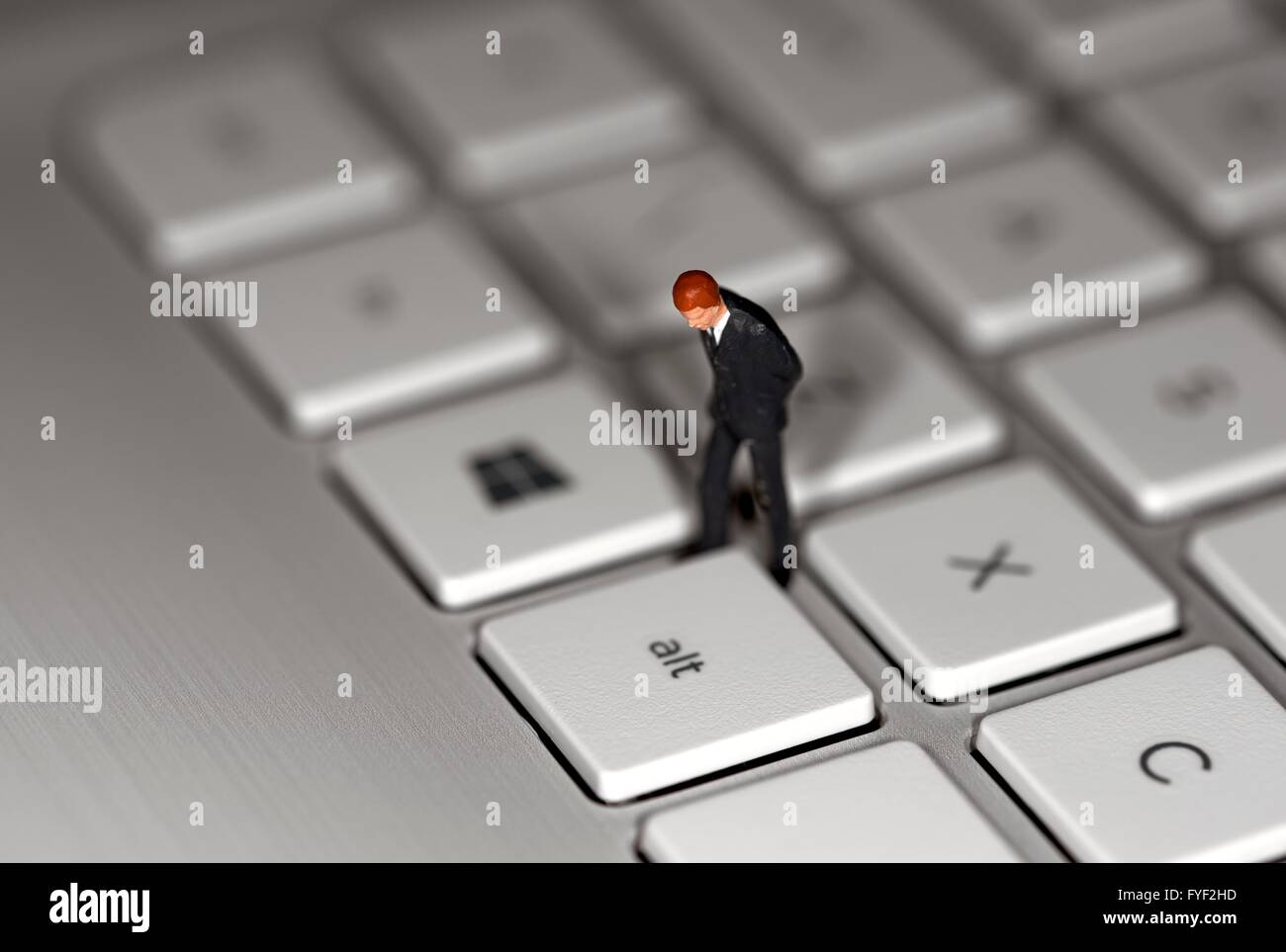 A miniature figurine business man standing on a laptop keyboard Stock ...