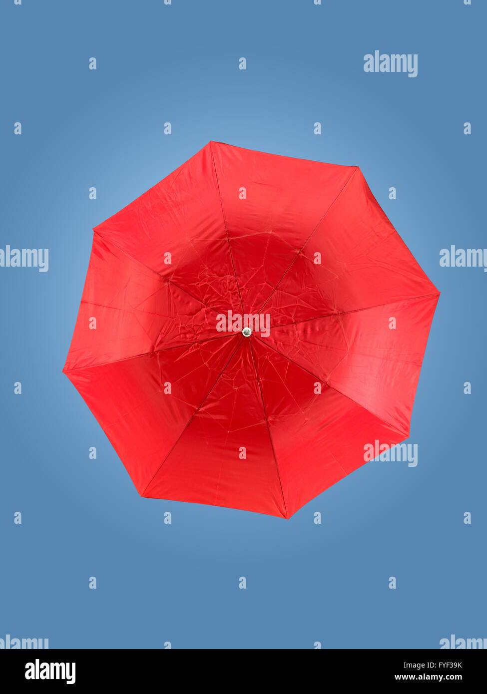 A red umbrella isolated against a blue background Stock Photo - Alamy