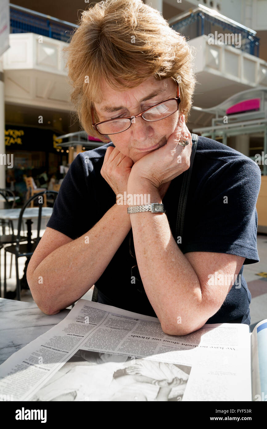 serious looking older woman reading morning papers. Southampton ...