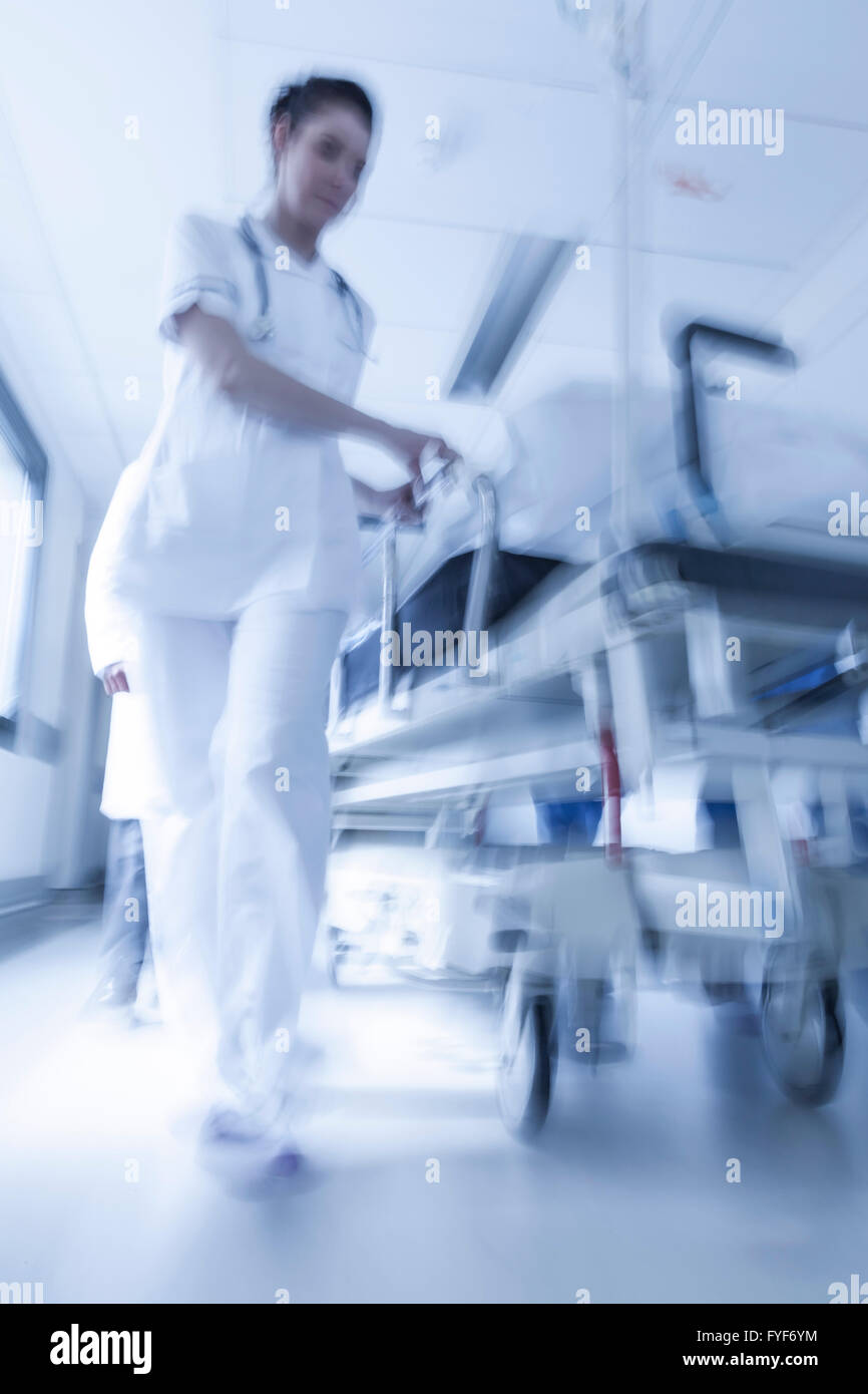 A motion blurred photograph of a female nurse or doctor pushing a ...