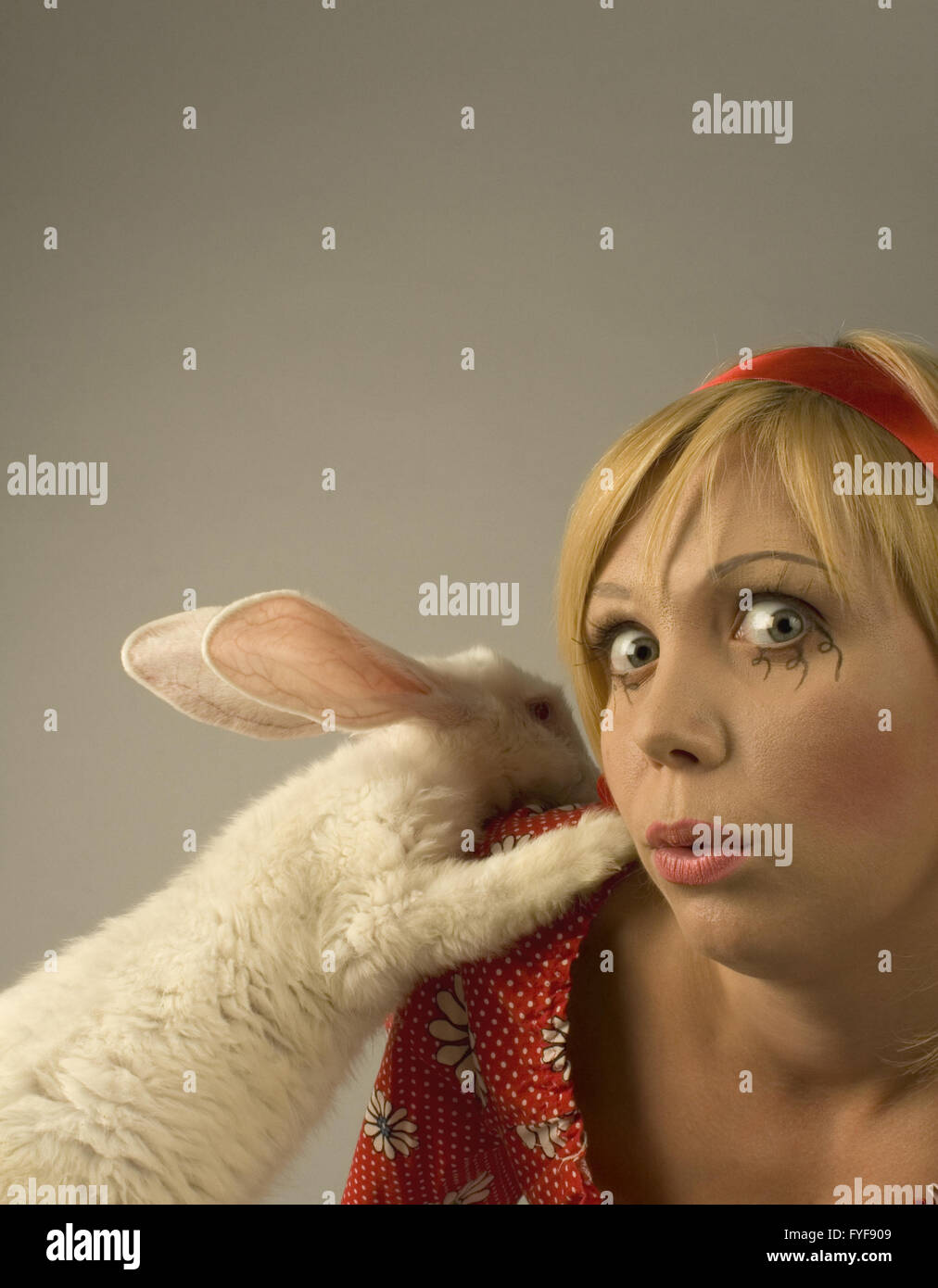 A white rabbit sitting on the shoulder of a beautiful blonde young ...