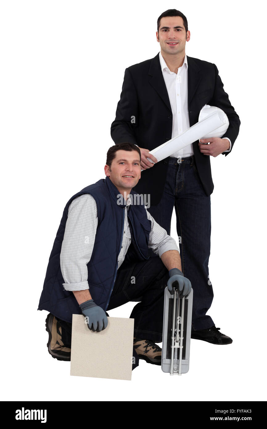 Portrait of an engineer and a workman holding a tile and a ceramic tile ...
