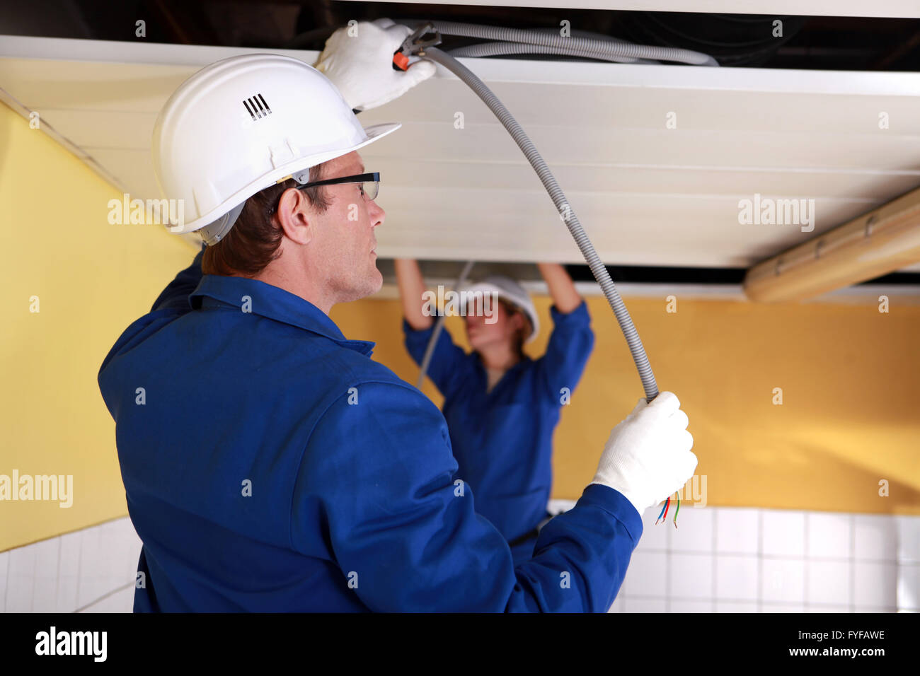 craftsman and craftswoman working on the electric installation Stock ...