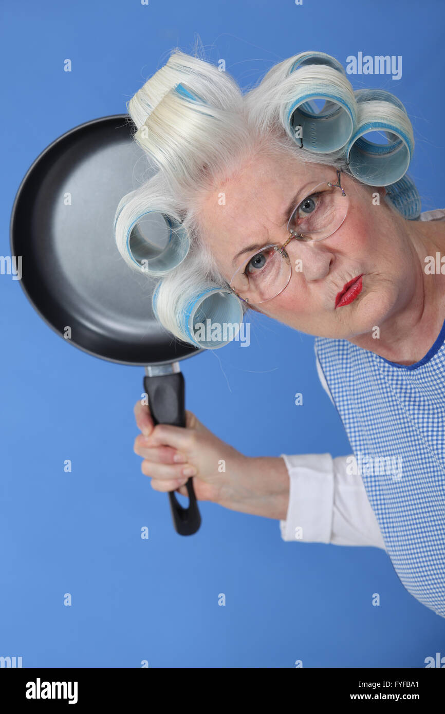 Angry old lady threatening to use frying pan Stock Photo - Alamy
