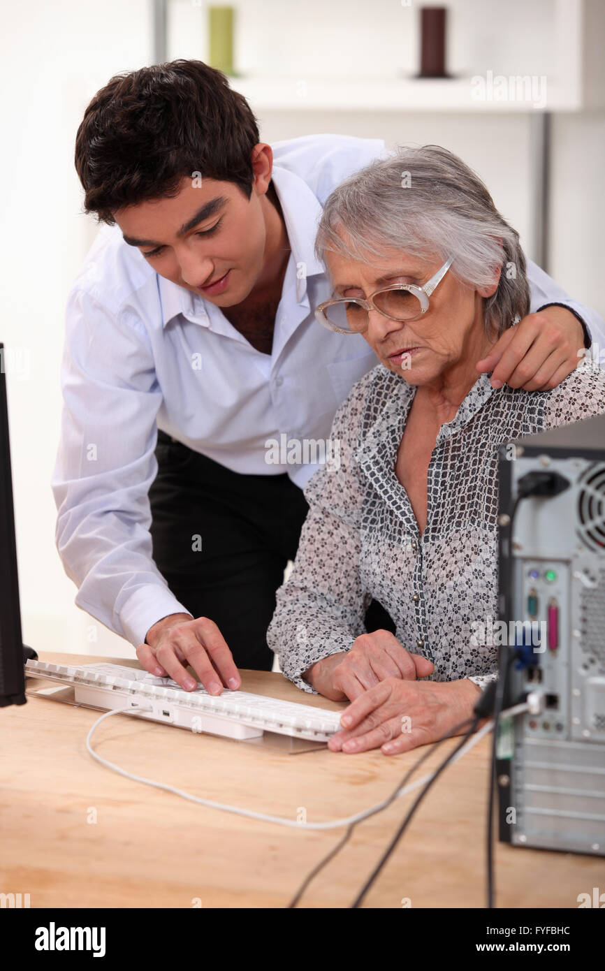 Grandson showing grandmother how to use computer Stock Photo - Alamy