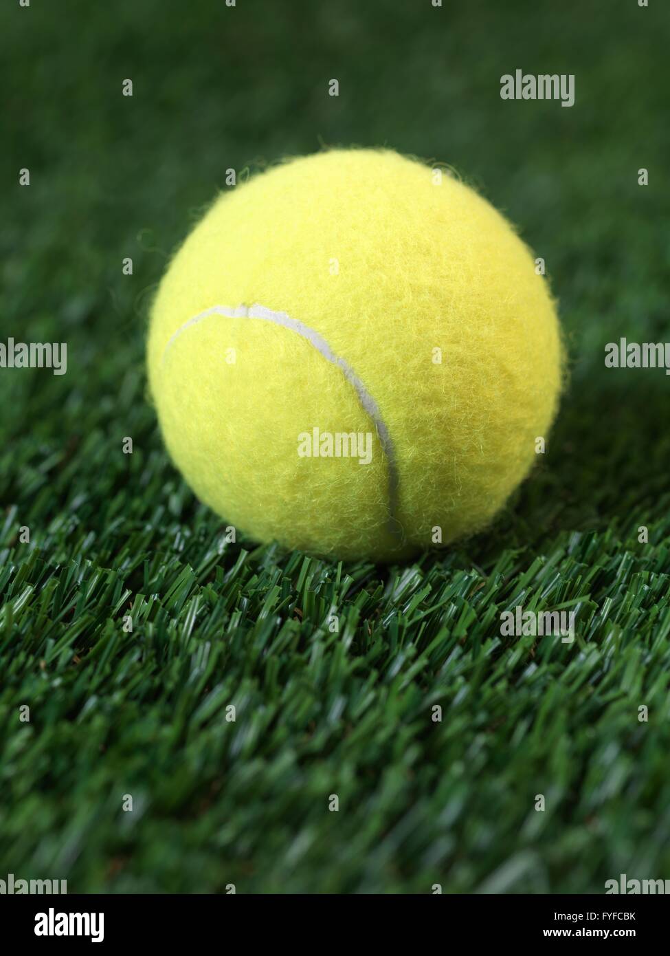 Sporting tennis balls on artificial green grass Stock Photo - Alamy