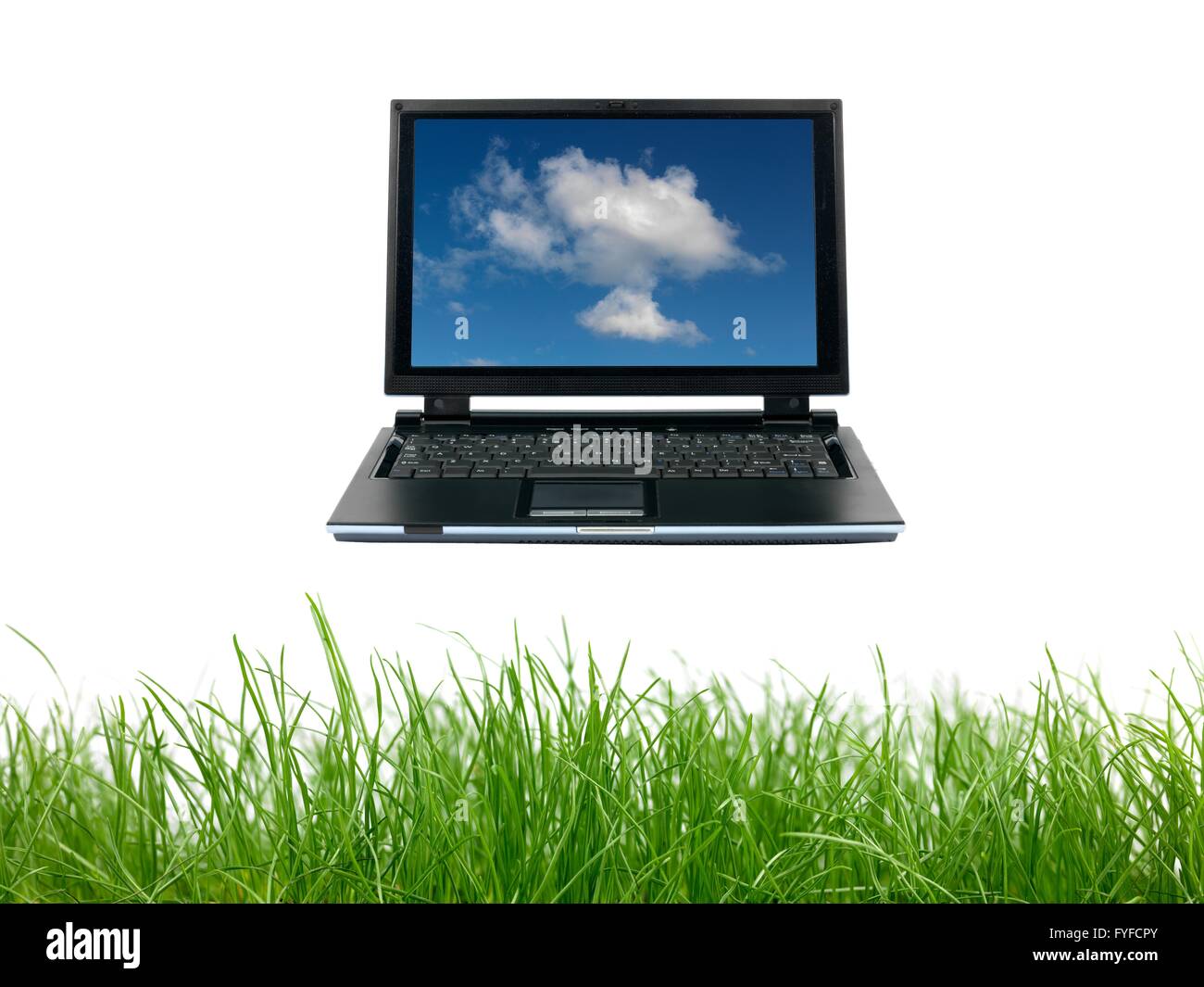 A laptop floating above green grass siolated against a white background ...