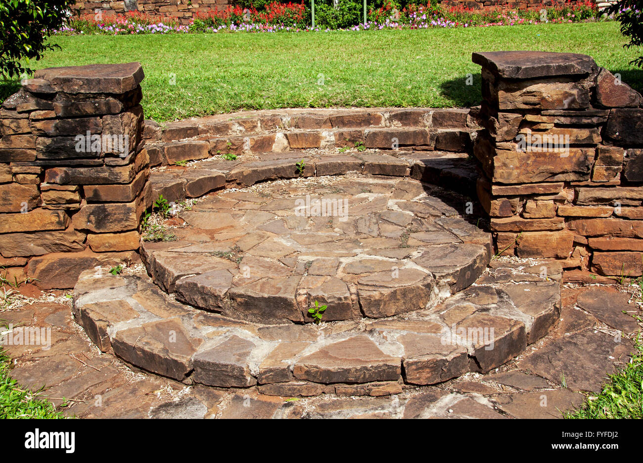 Stone wall and paved patterned and textured walkway in botanical garden ...