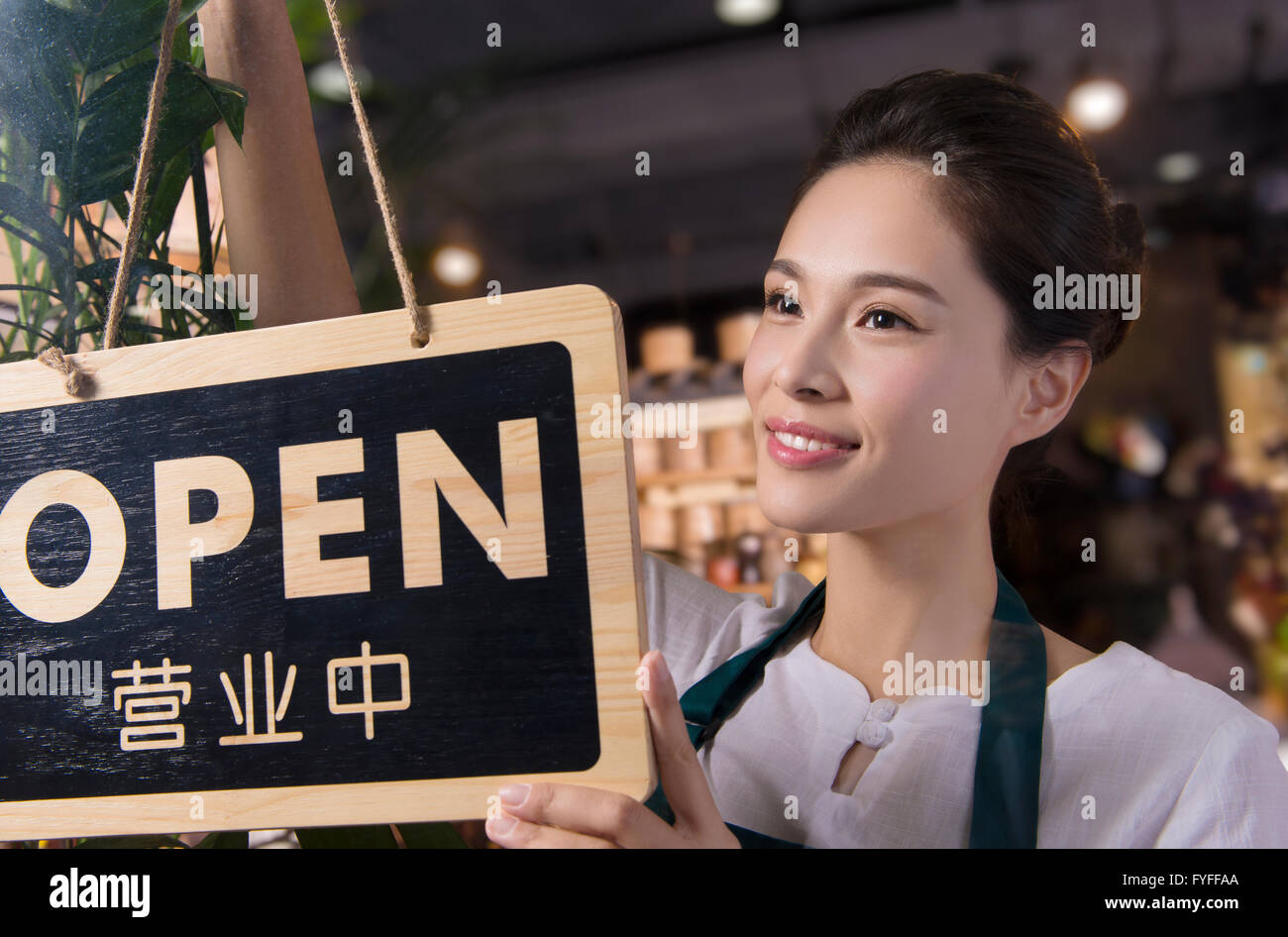 Tea house owner putting up open sign Stock Photo - Alamy