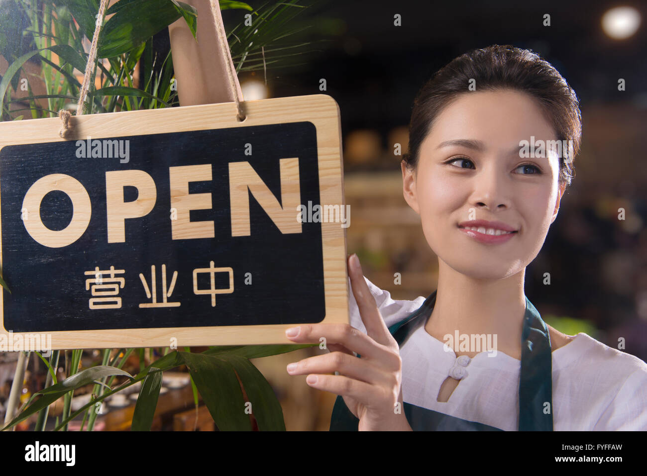 Tea house owner putting up open sign Stock Photo - Alamy