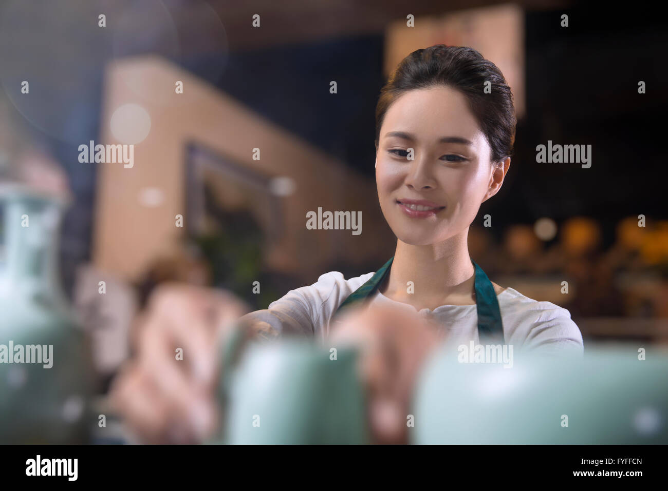 Antique shop owner arranging window display Stock Photo - Alamy
