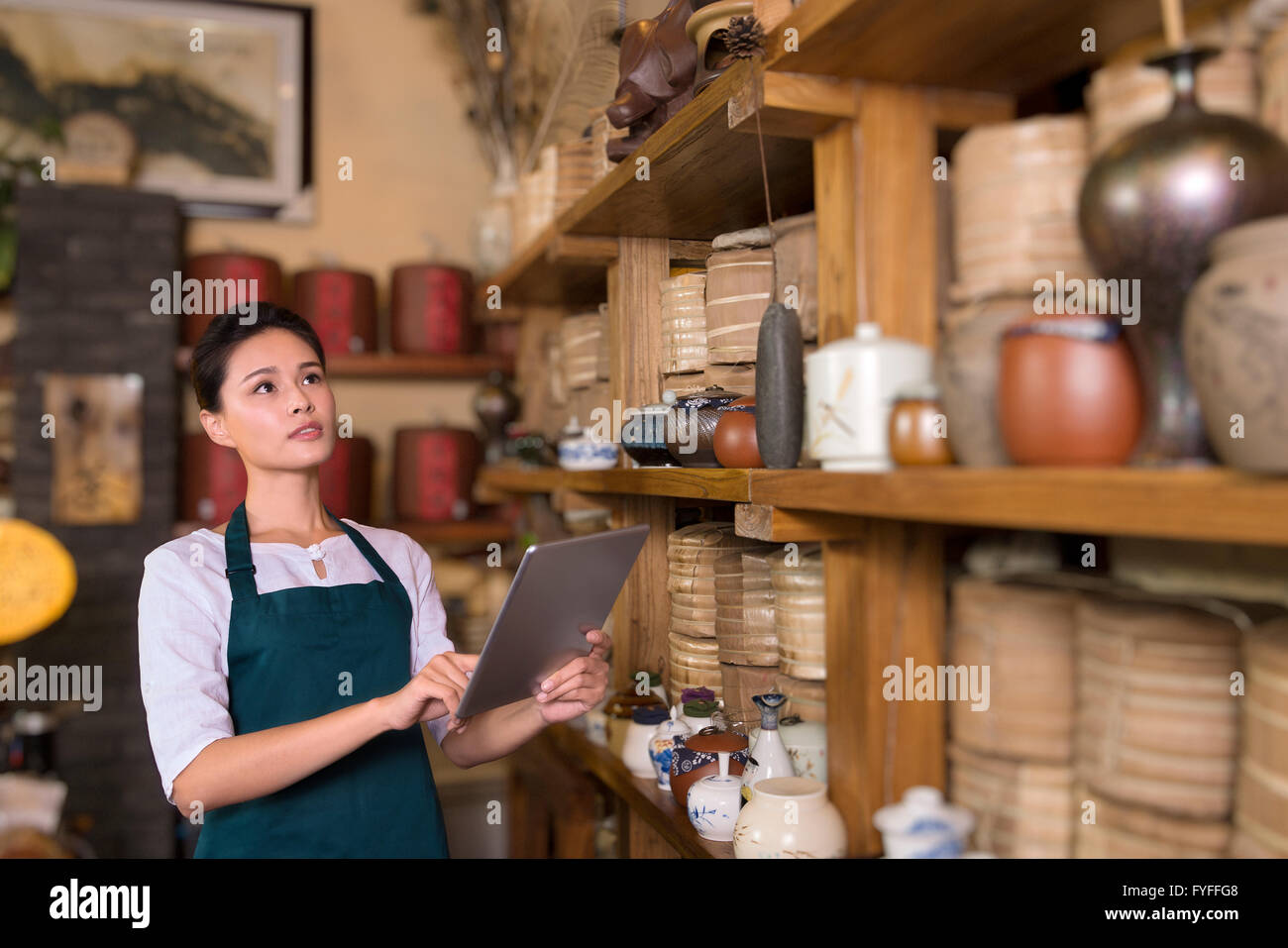 Tea house owner checking inventory using digital tablet Stock Photo - Alamy
