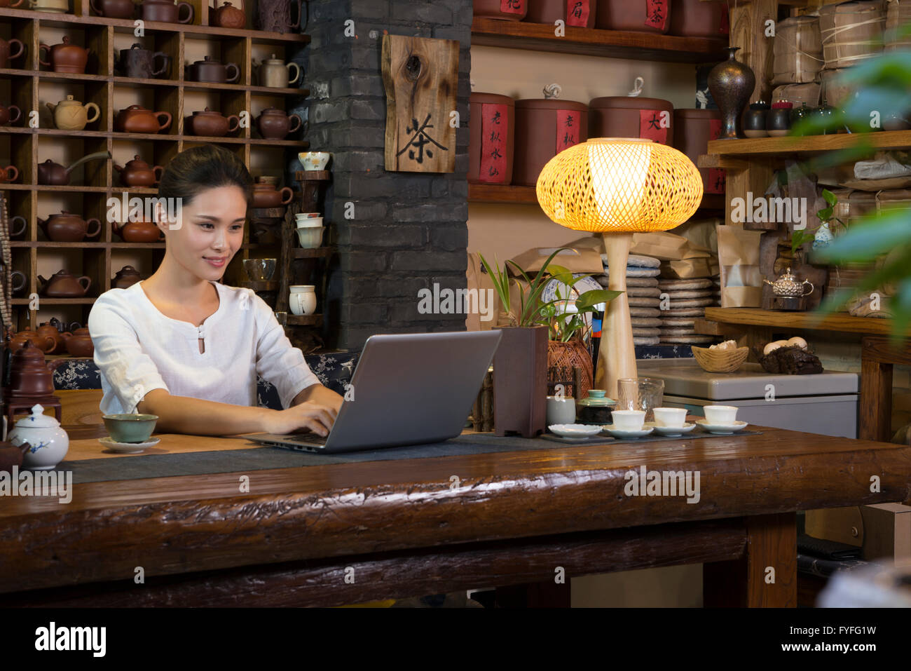 Tea house owner using laptop Stock Photo - Alamy