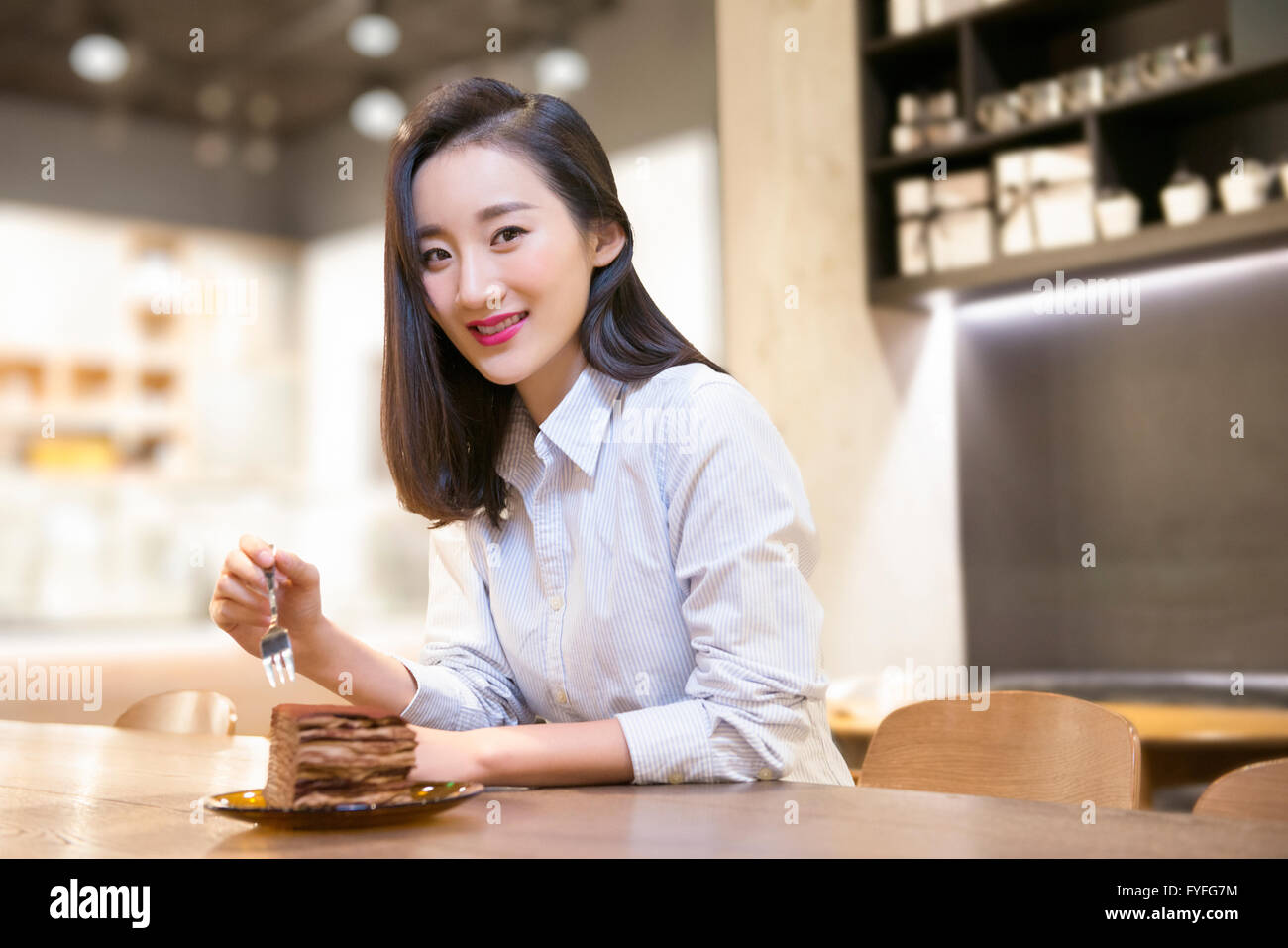 Woman eating cake in bakery Stock Photo - Alamy