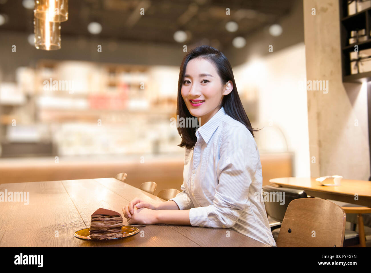 Woman eating cake in bakery Stock Photo - Alamy