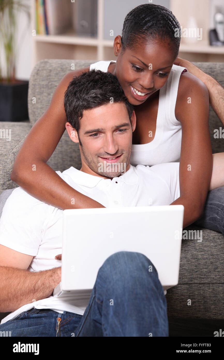 black woman is cuddling her boyfriend and doing computer Stock Photo ...