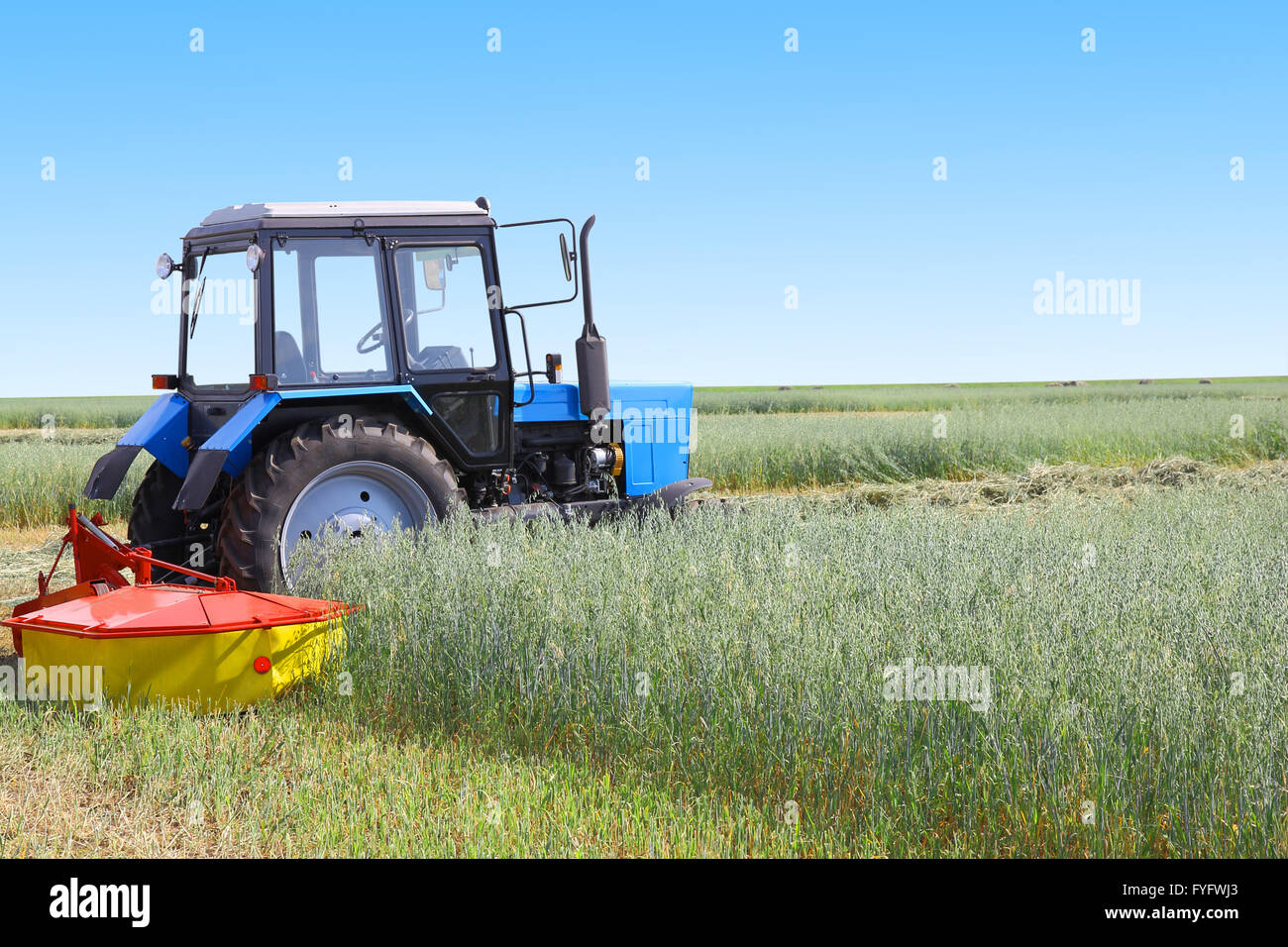 Tractor in a field, agricultural scene in summer Stock Photo - Alamy