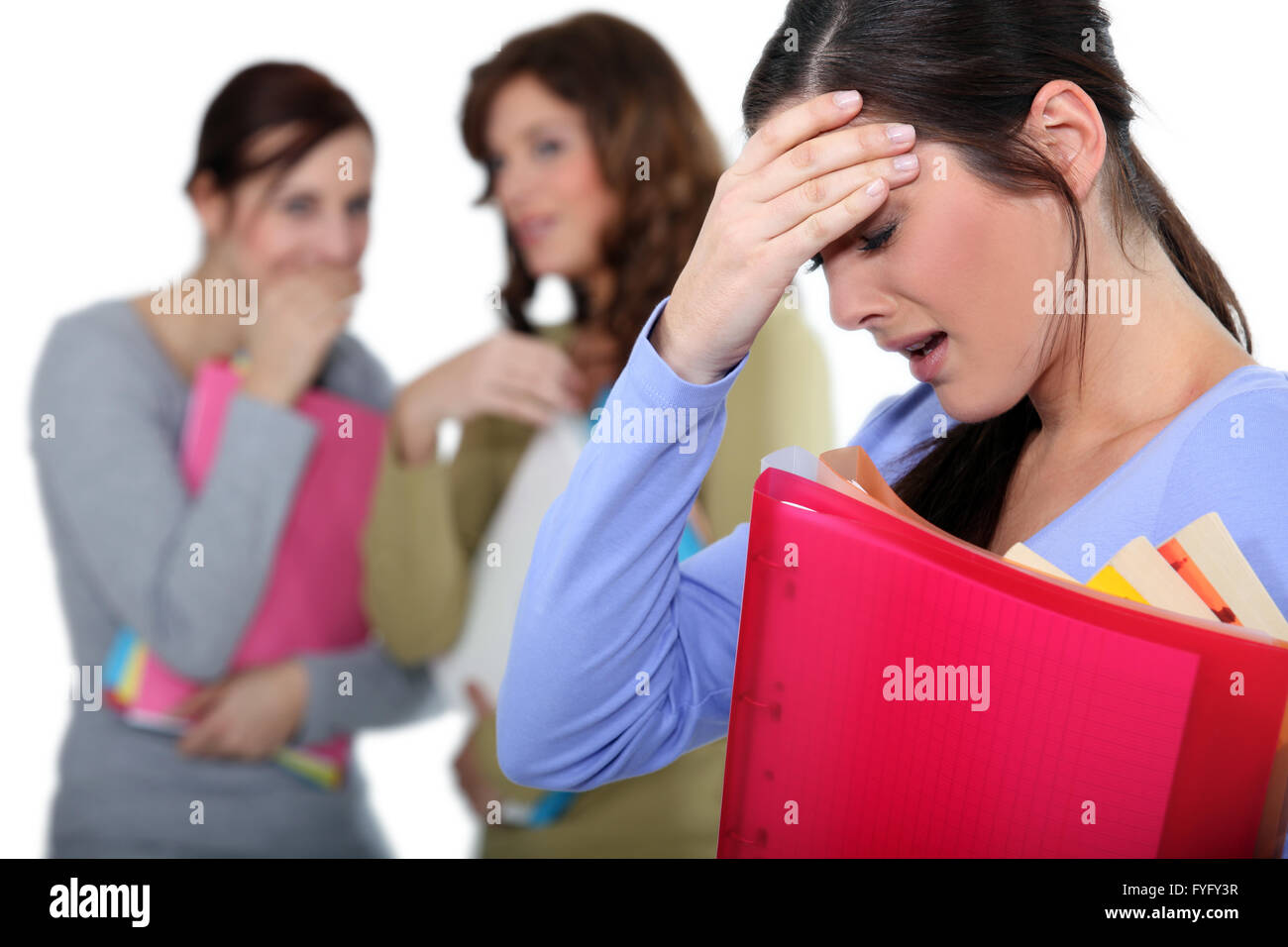 two female colleagues mocking a woman in trouble Stock Photo - Alamy