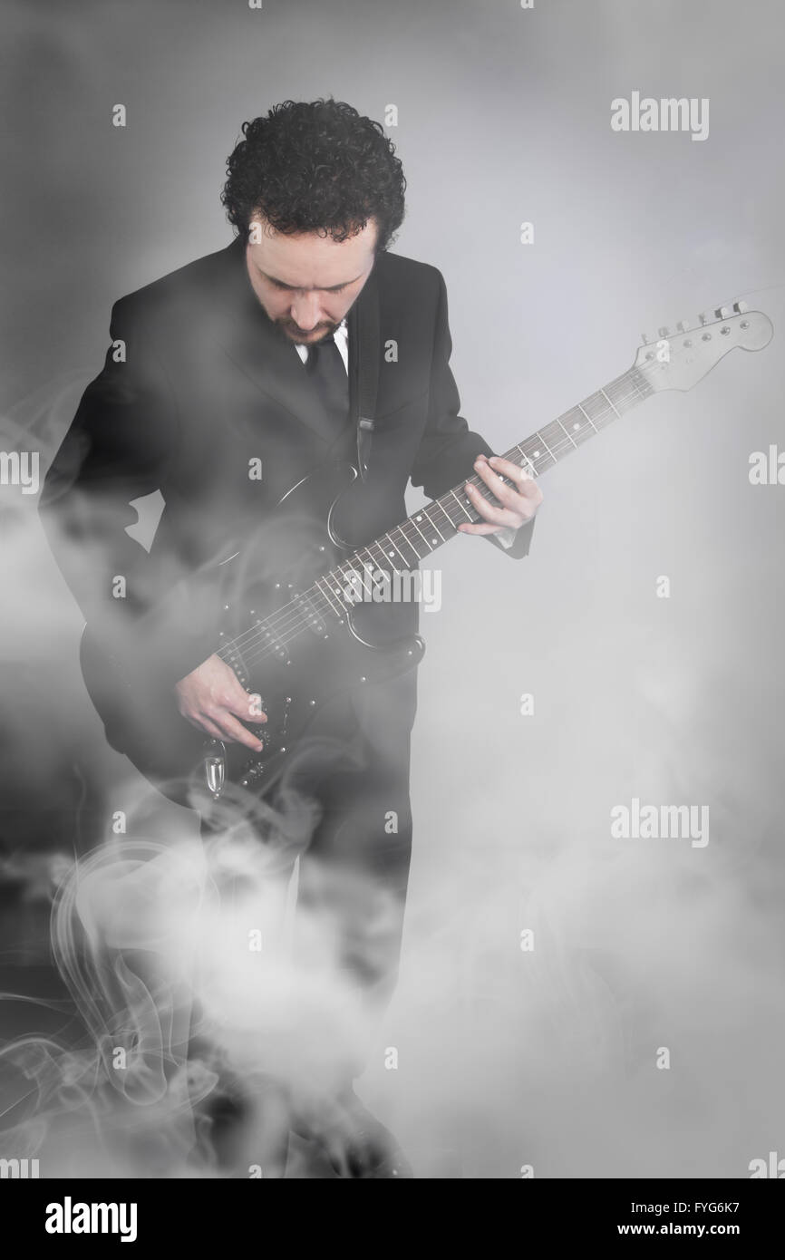 guitarist on stage full of smoke, man with black suit and guitar Stock ...
