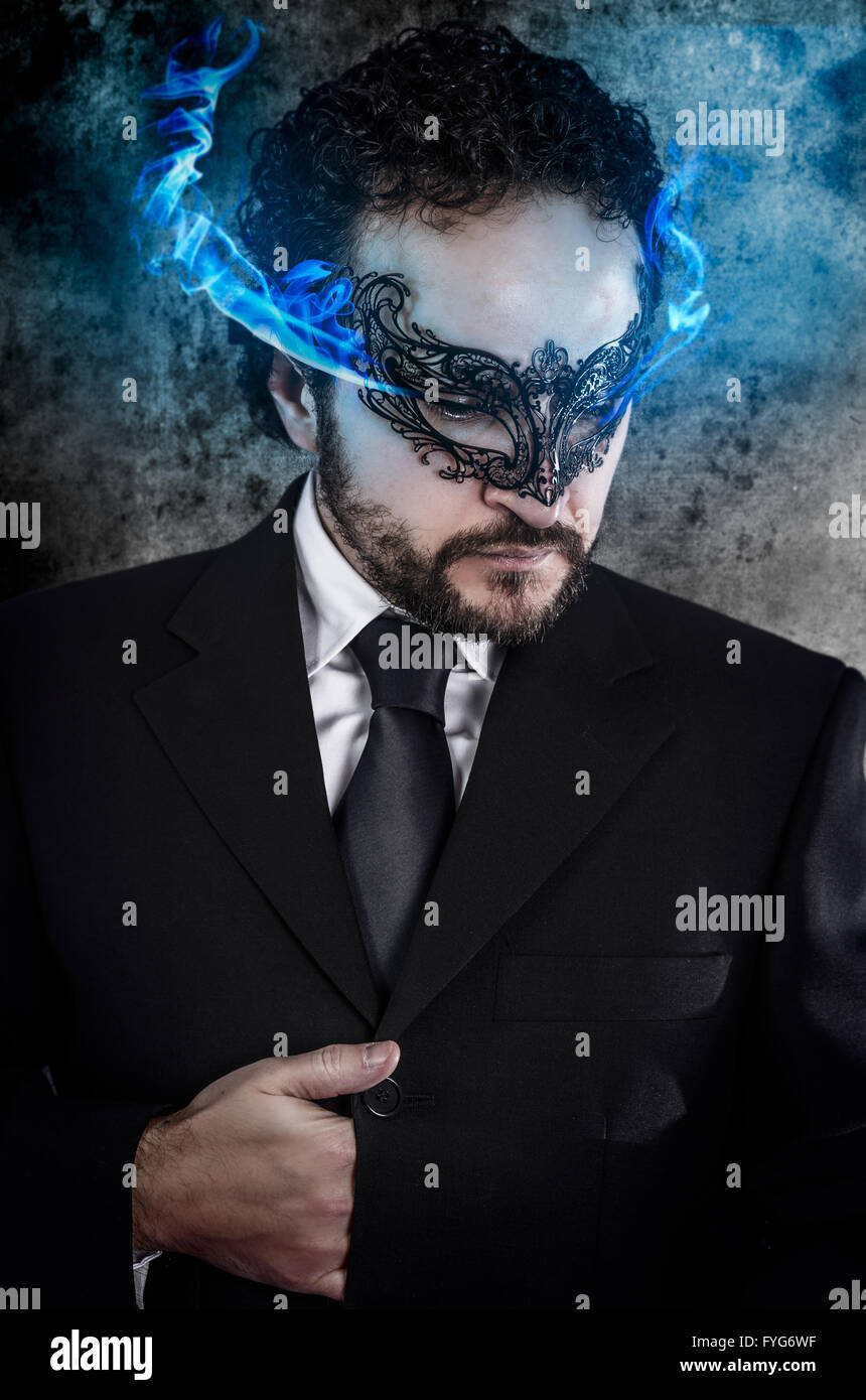 concept business, man with fiery eyes and Venetian mask wearing black ...