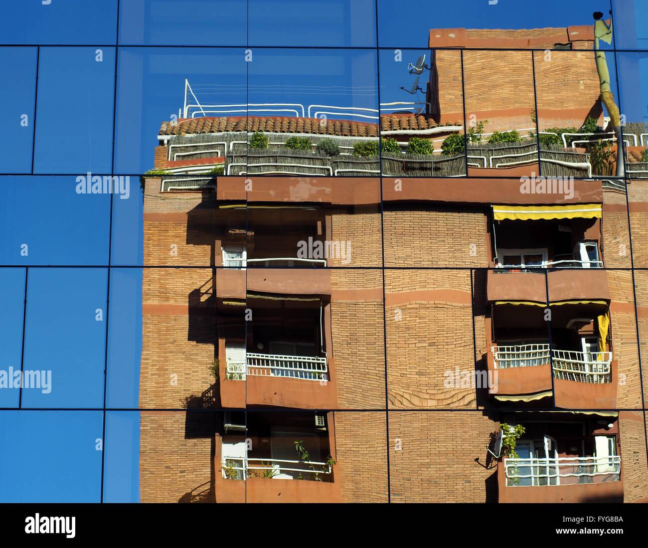Reflection of apartment building in Barcelona in glass-fronted office ...