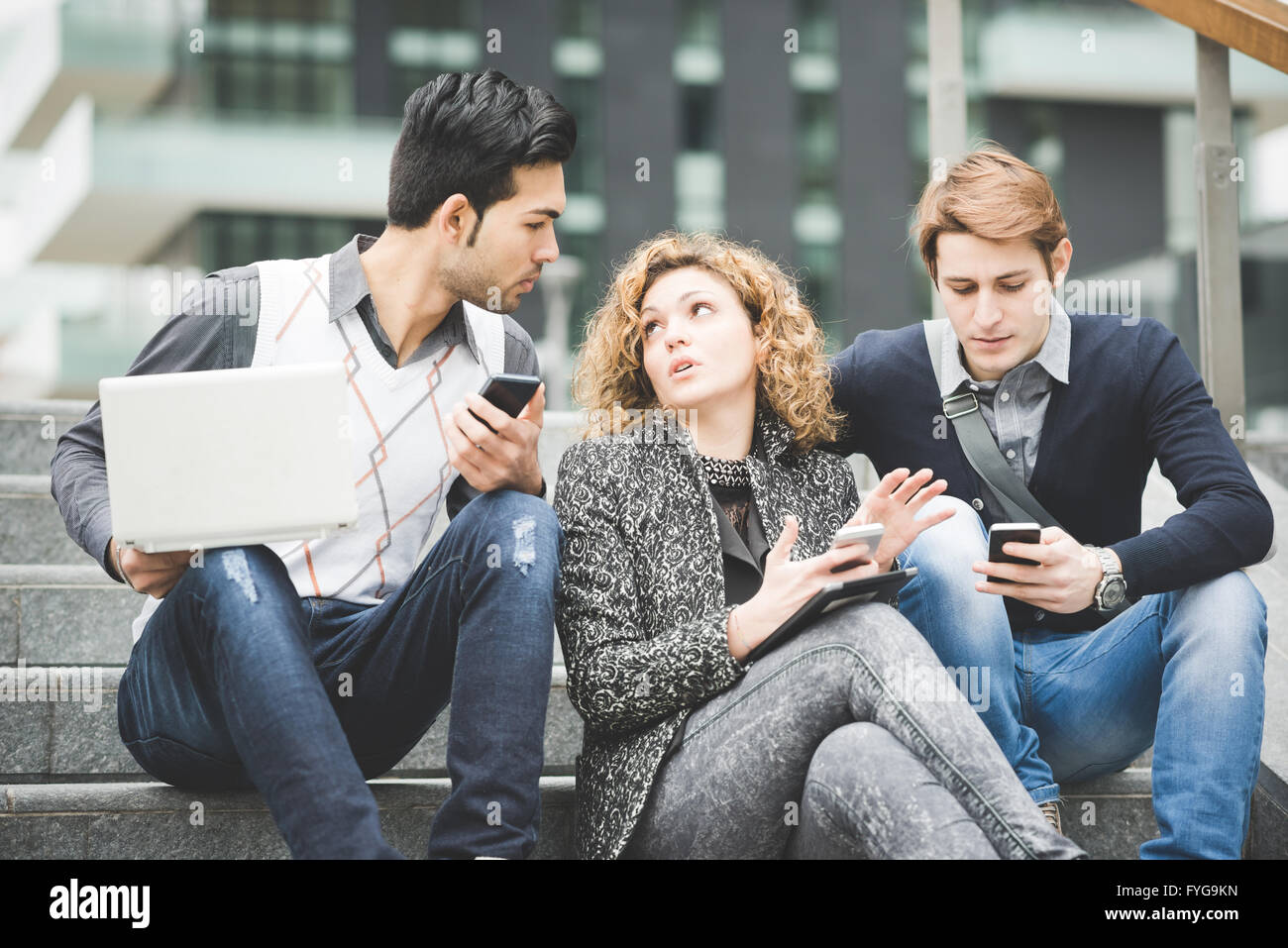 Multiracial business people working outdoor sitting on the staircase ...