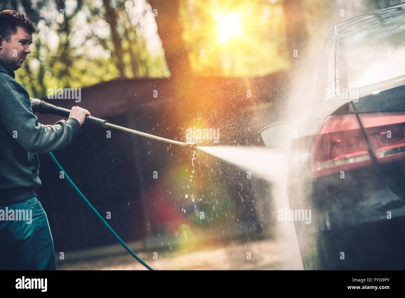 High Pressured Water Car Cleaning and Washing. Springtime Backyard Car ...