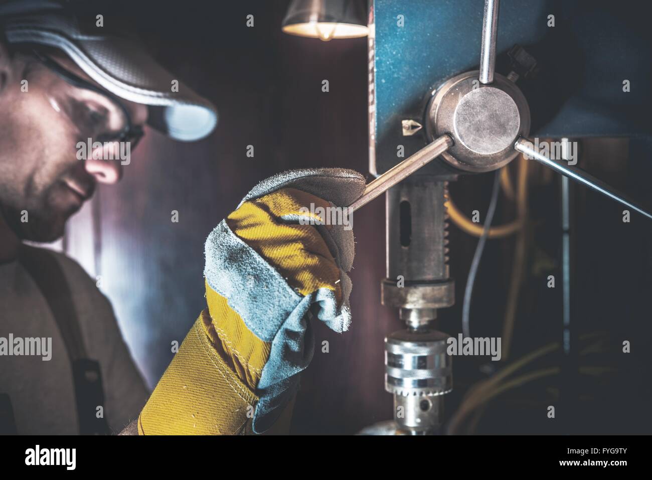 Small Drill Works in a Garage. Caucasian Men Using Metal Driller ...