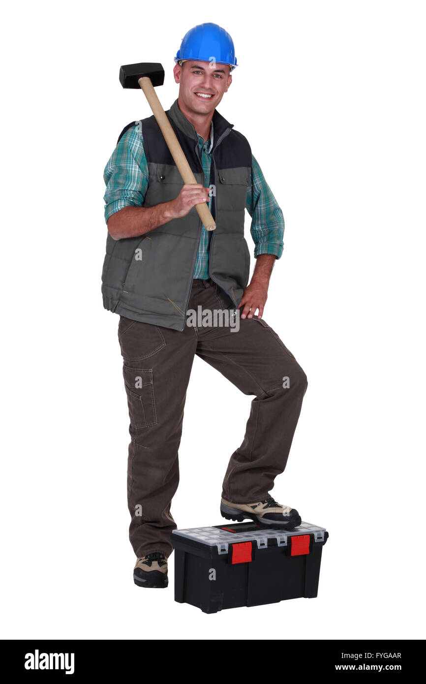 Man with sledge-hammer resting foot on tool-box Stock Photo - Alamy